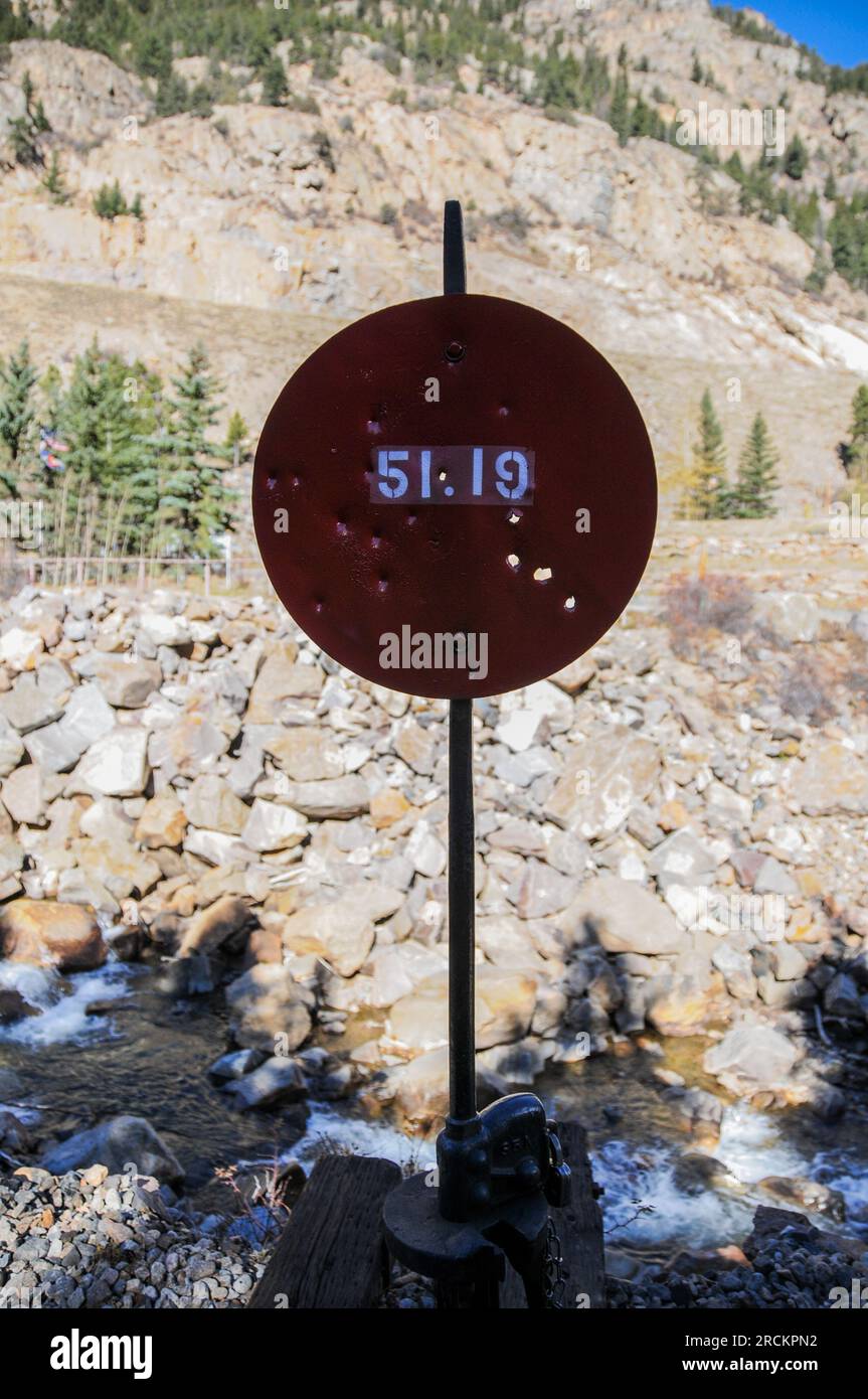 Target practice gun shots and bullet holes on red railway sign in ...