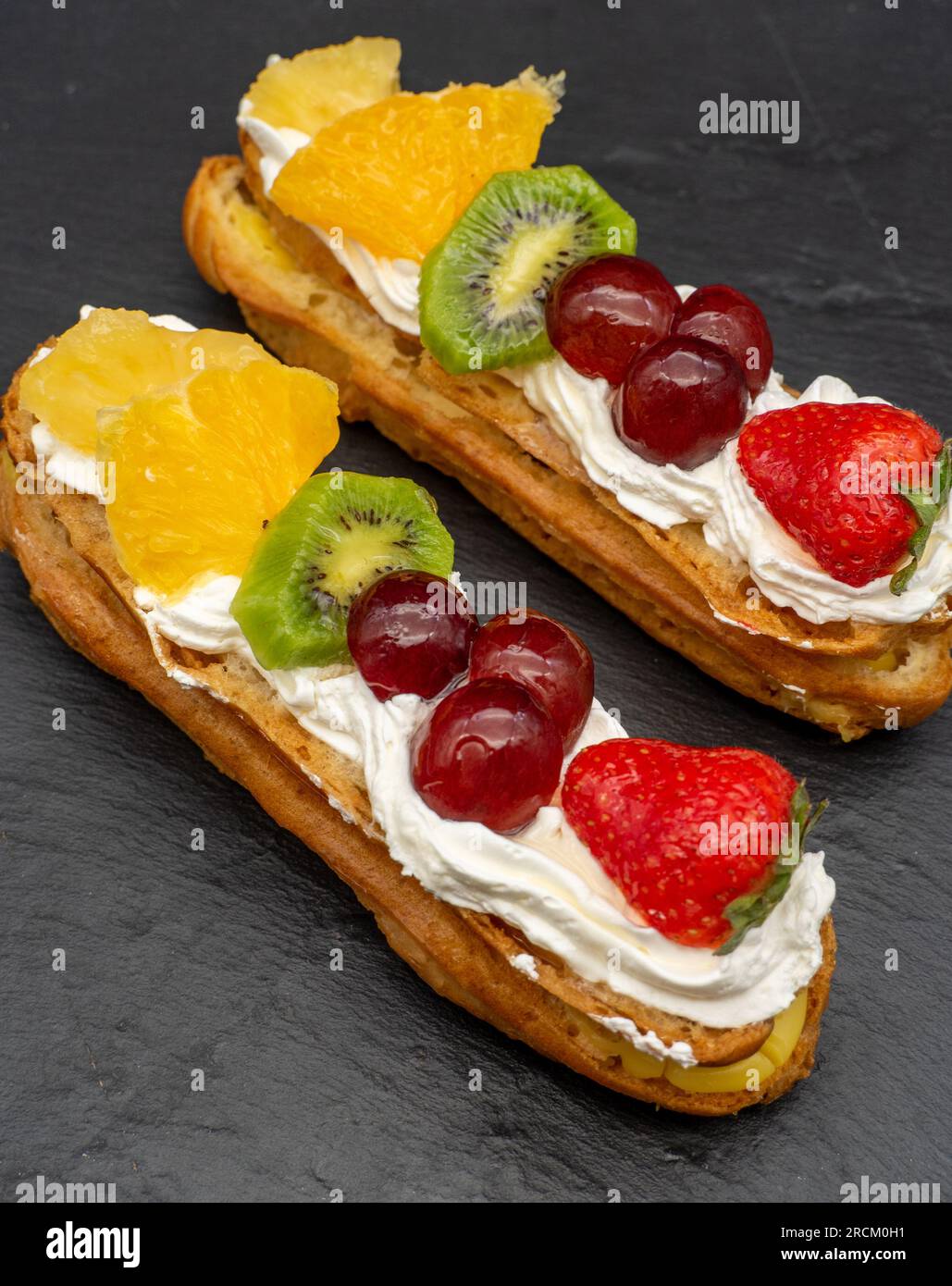 homemade french eclairs with cream and assorted season fruits Stock ...