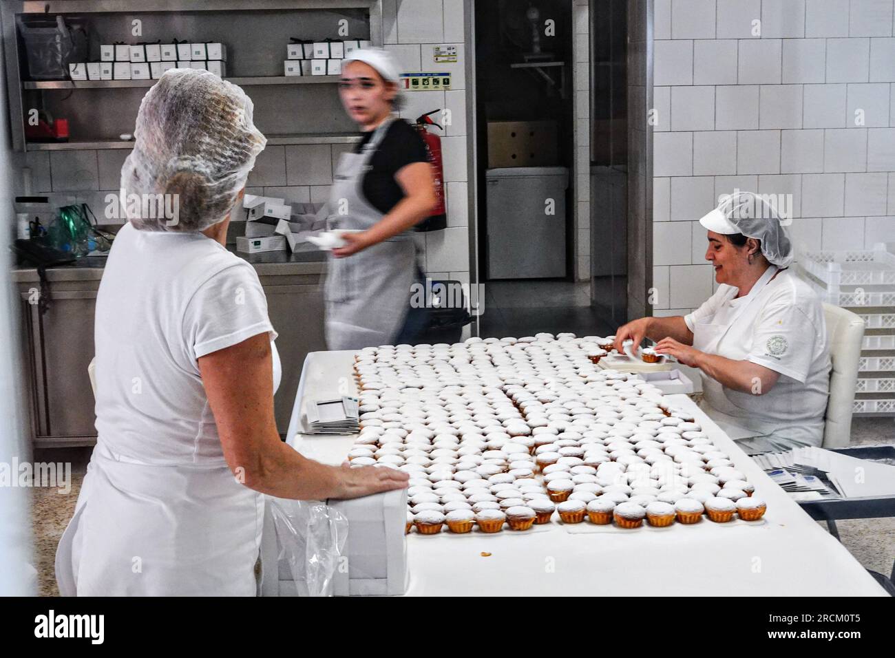 Women bakers package freshly sugared queijadas, a traditional custard ...