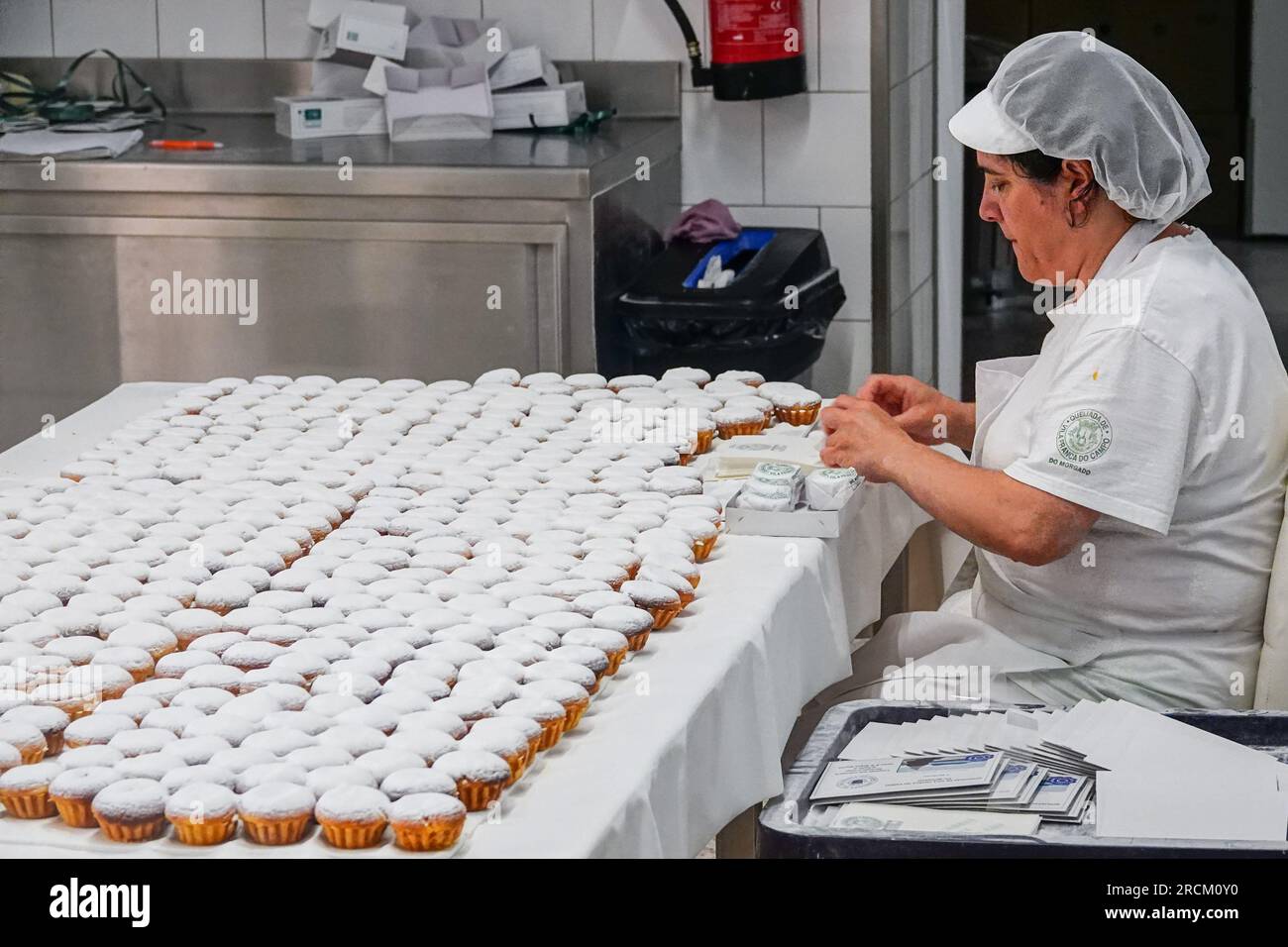 Women bakers package freshly sugared queijadas, a traditional custard pastry, at the Queijadas ...