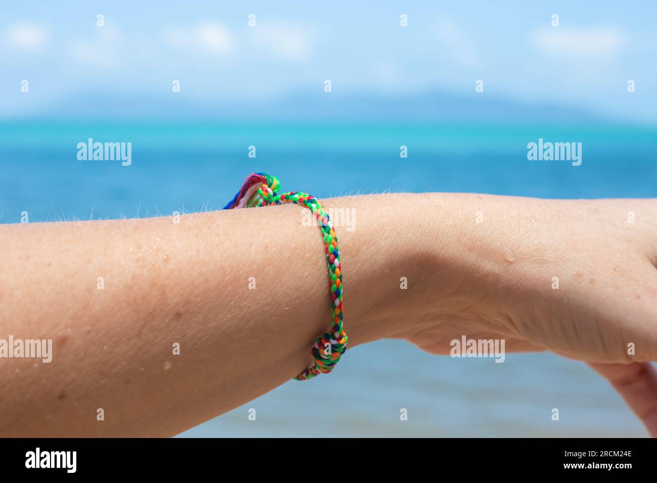 Colored thread on a woman's wrist. Sai Sin, rope tied by a monk, Thai ...