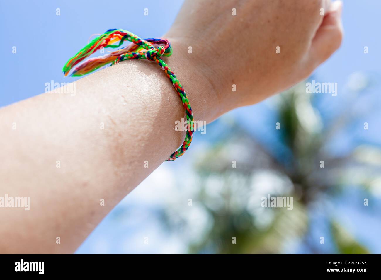 Colored thread on a woman's wrist. Sai Sin, rope tied by a monk, Thai ...