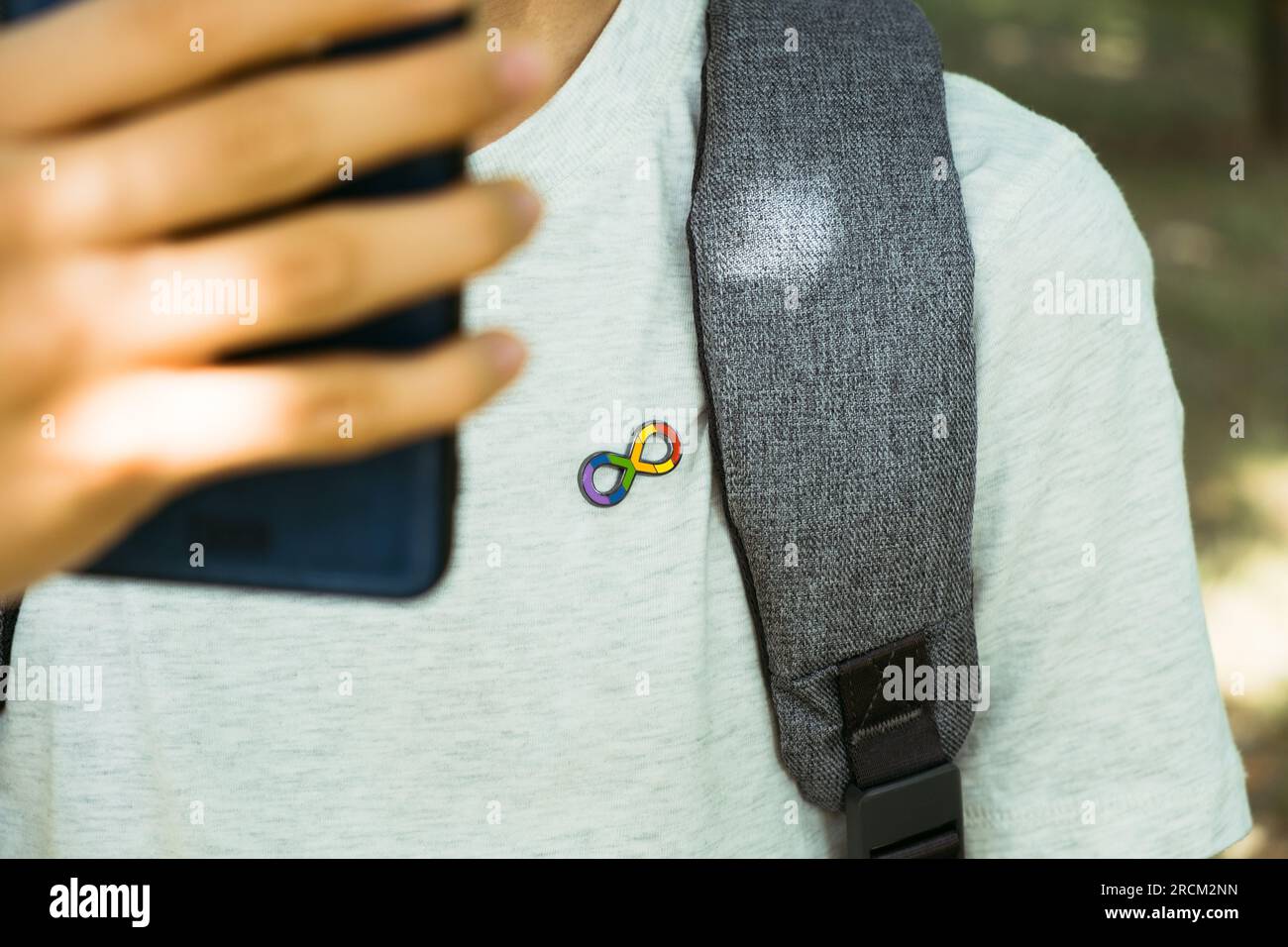 Teenage boy with autism infinity rainbow symbol sign using smartphone ...