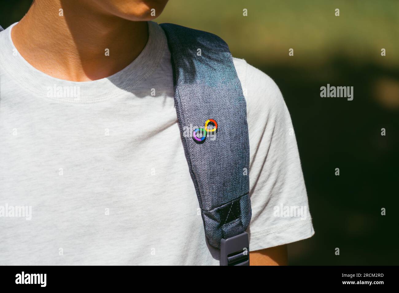 Adolescent boy with backpack with autism infinity rainbow symbol sign ...