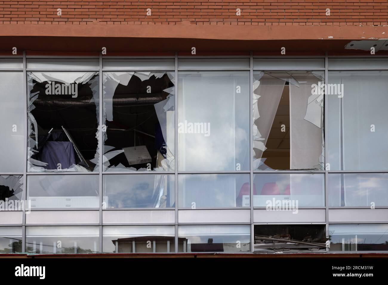 Broken windows of civilian building of bomb explosion. Shards of glass ...