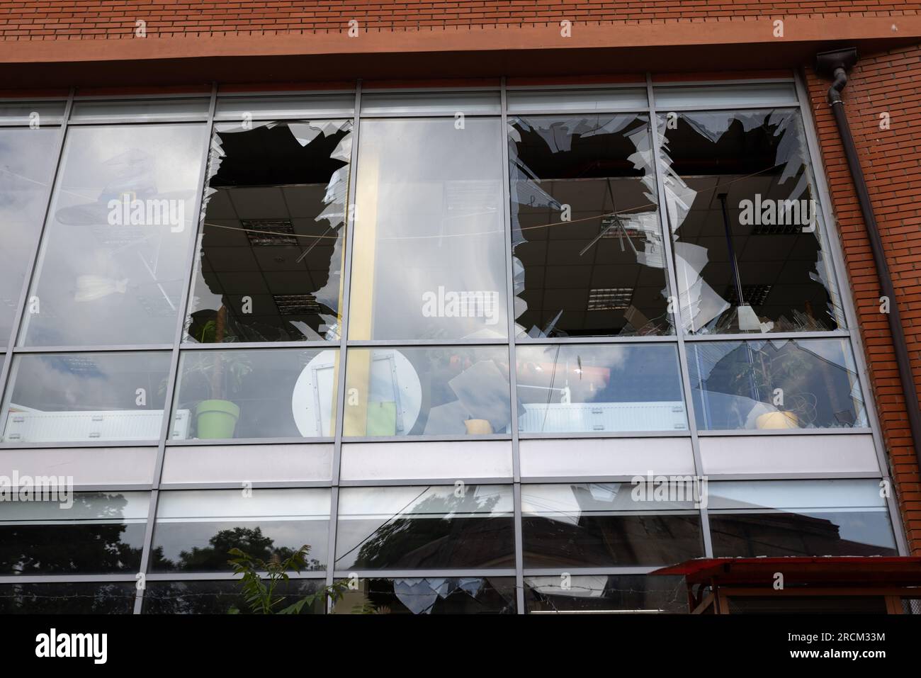 Broken windows of civilian building of bomb explosion. Shards of glass ...