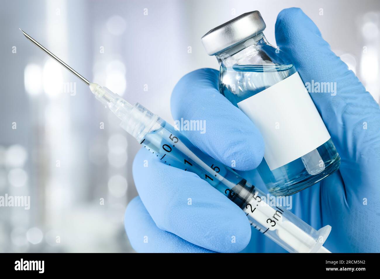 Healthcare concept with a hand in blue medical gloves holding a vaccine ...