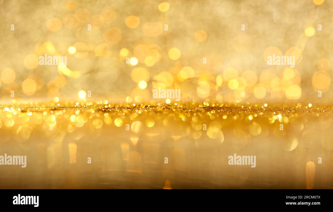 Abstract bokeh of glowing yellow lights and sparkling gold glitter background or wallpaper Stock ...