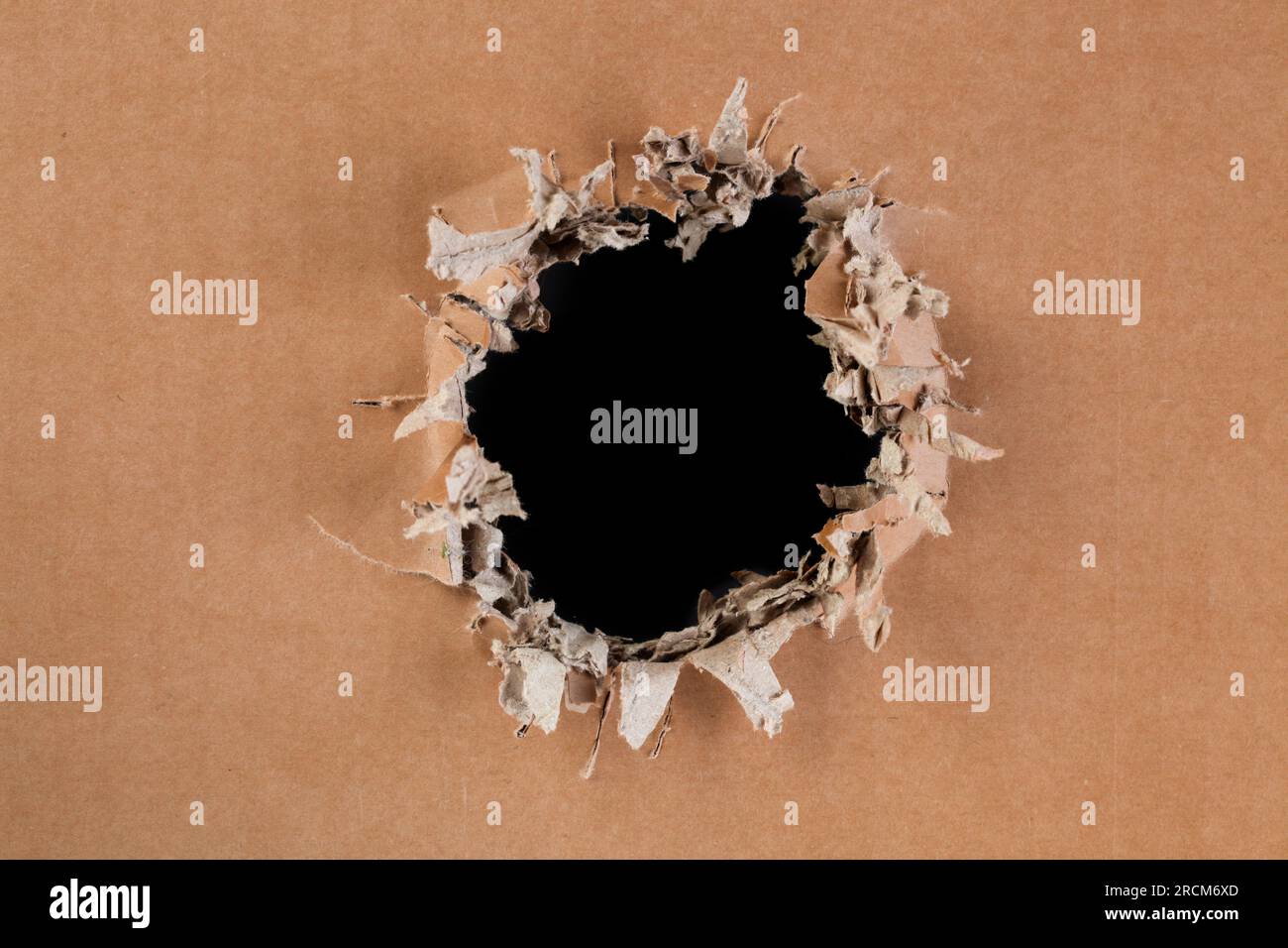 Blank cardboard with rough, ripped and torn hole in the center with ...