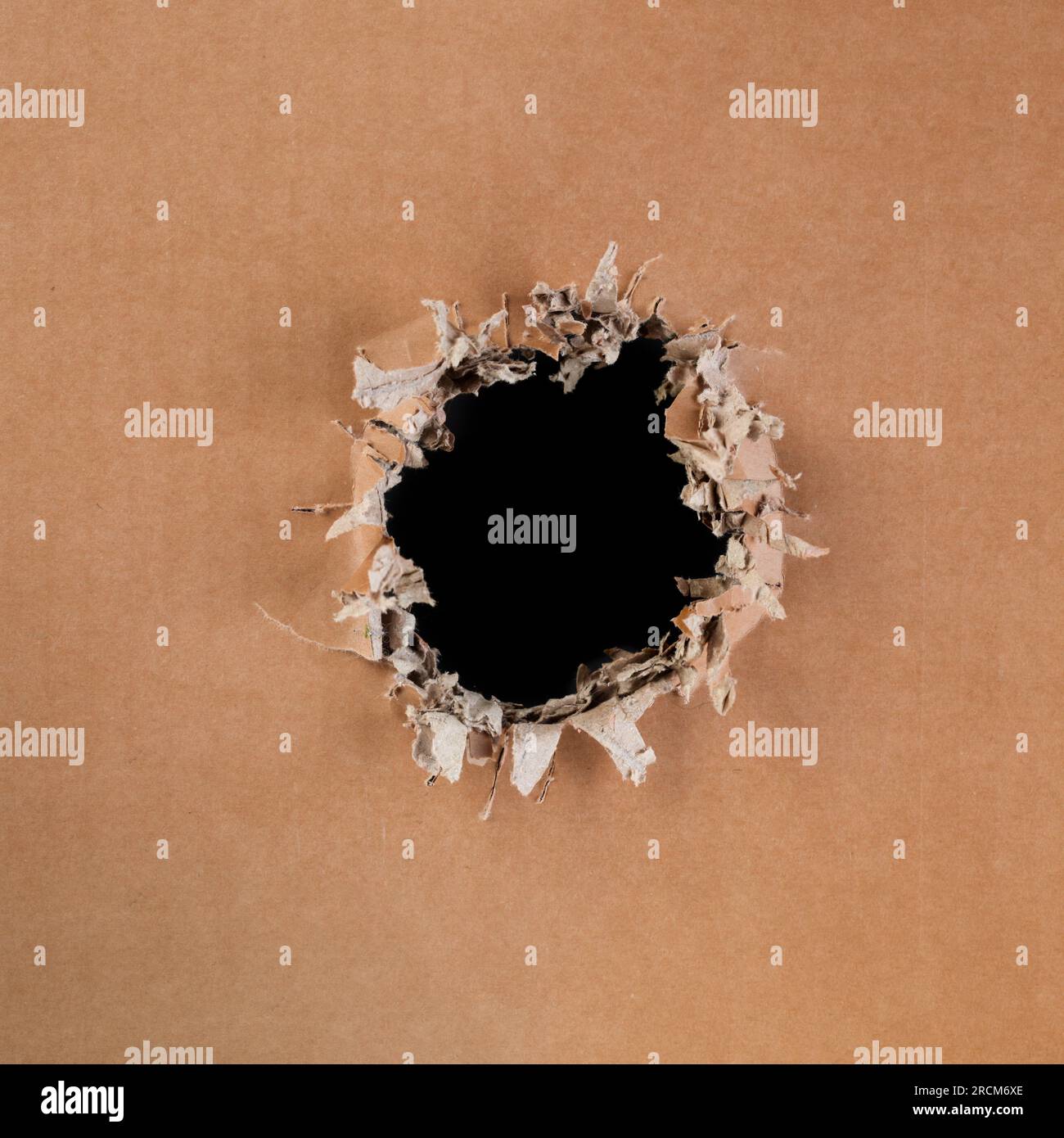 Blank cardboard with rough, ripped and torn hole in the center with ...