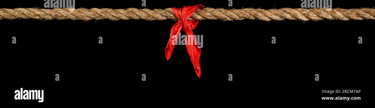 Long tug of war rope pulled tight, with red ribbon tie. Concept of ...