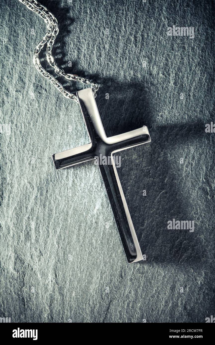 Christian cross necklace on slate background with the crucifix casting ...