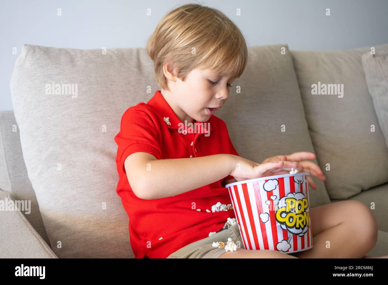 young boy eating popcorn and sharing from a bowl Stock Photo - Alamy