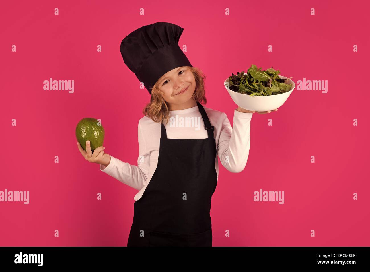 Kid cook with avocado and vegetable. Kid chef cook prepares food on ...