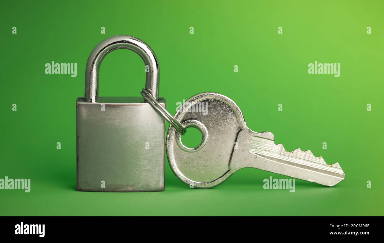 Simple lock and key. Small worn padlock with over large shiny key ...