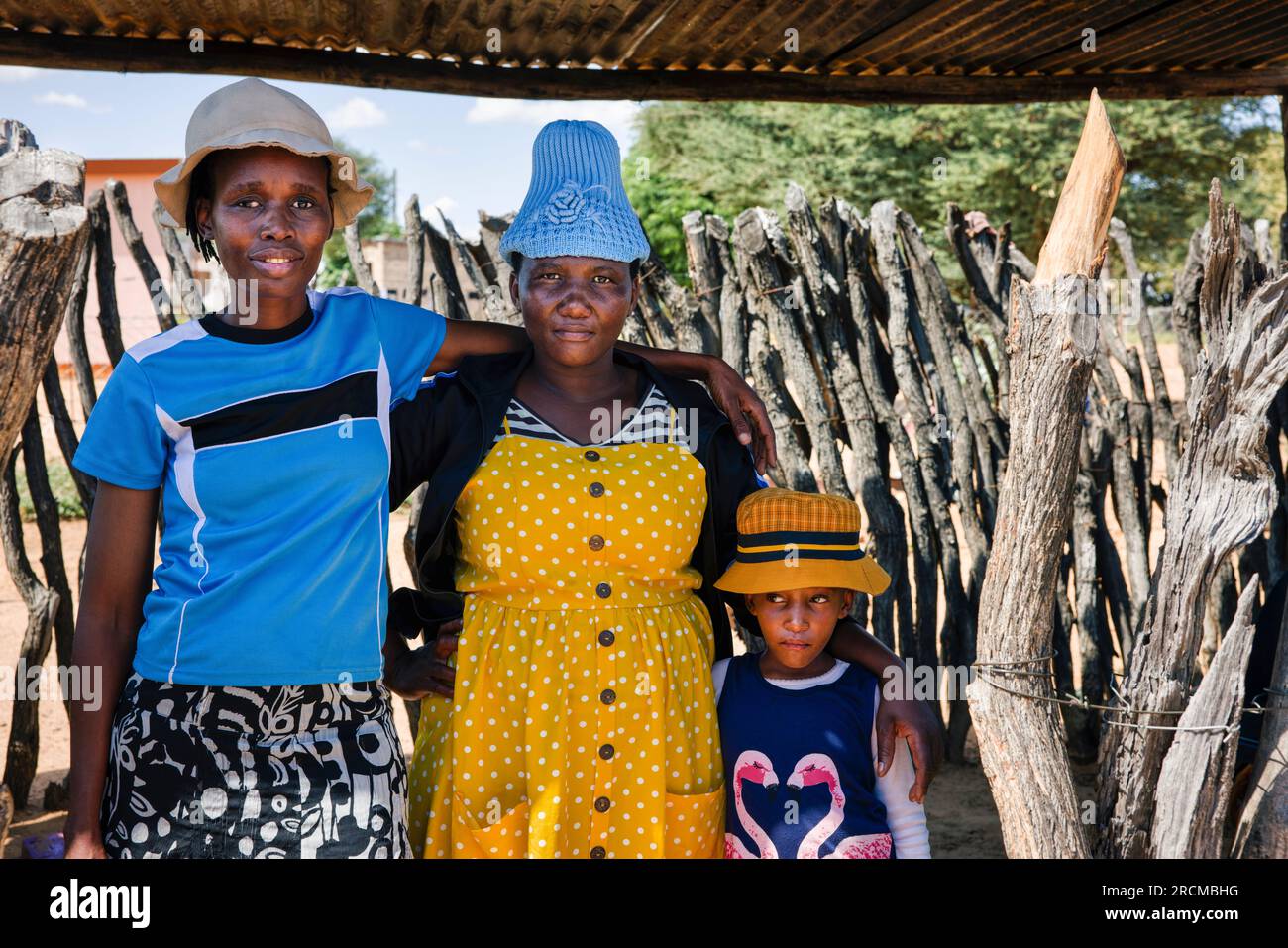 village african family and child standing under the metal shed in front ...
