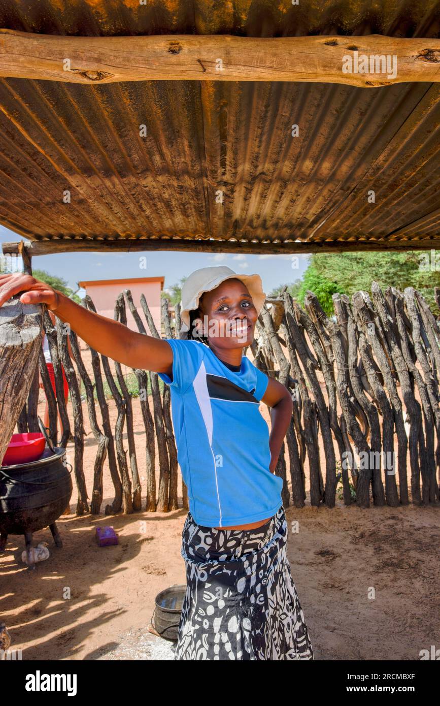 young village african woman with a hat standing under the shed of an ...