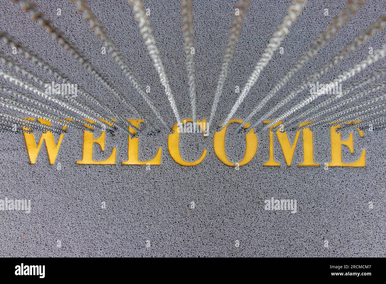 The inscription Welcome on a carpet under the hanged chains Stock Photo ...