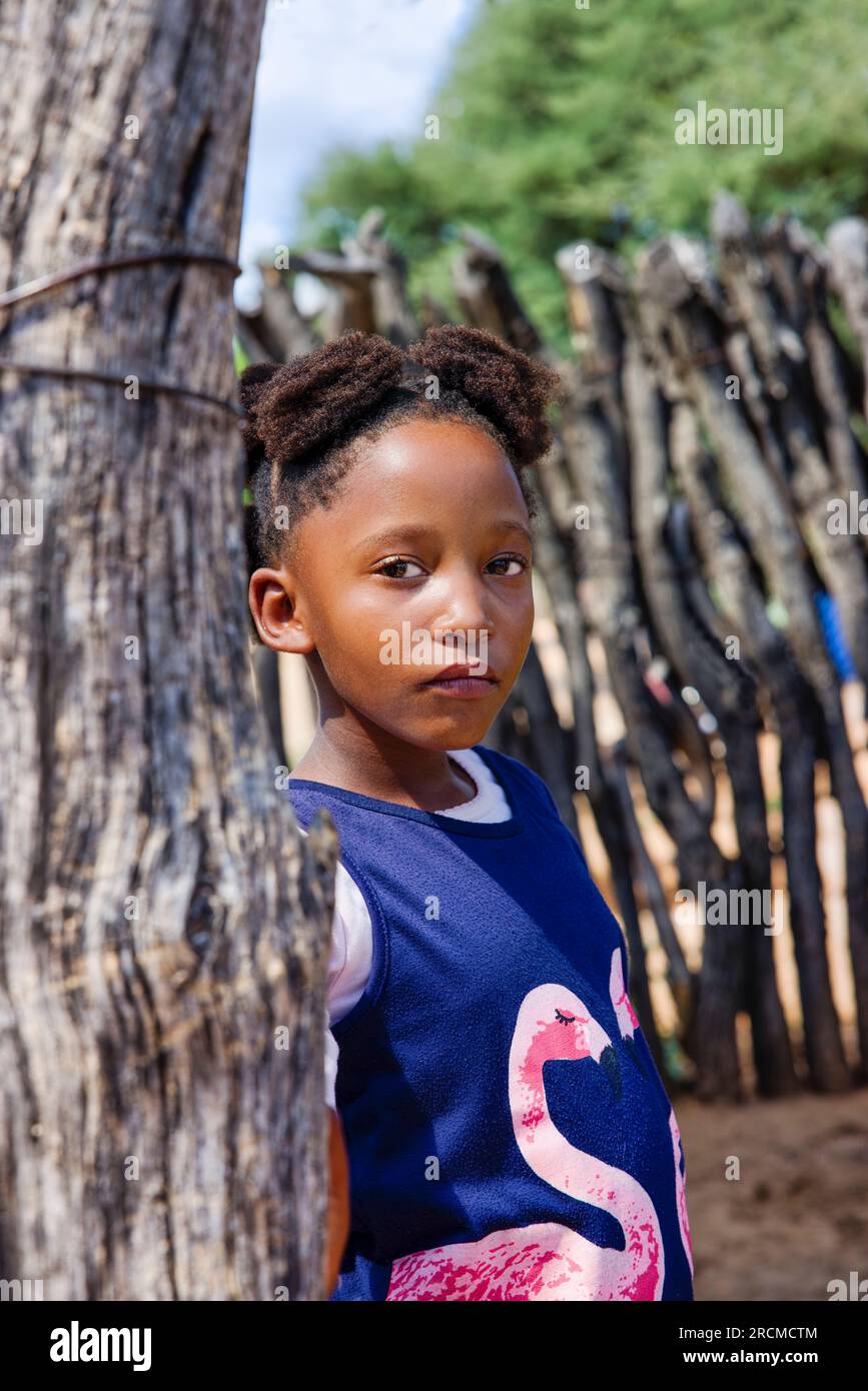 African village child standing in the yard, outdoors kitchen in rural ...