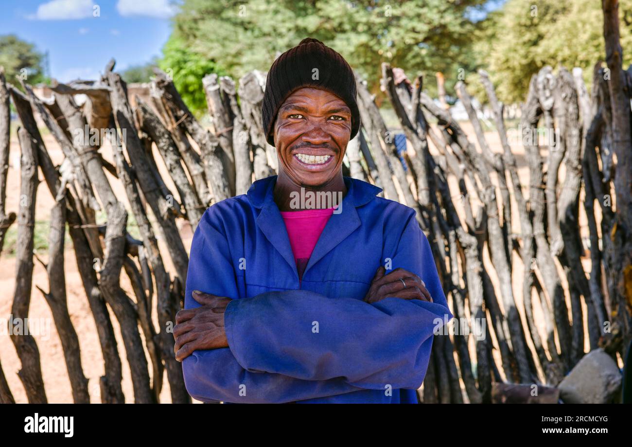 African village man standing in the yard, outdoors kitchen in rural ...