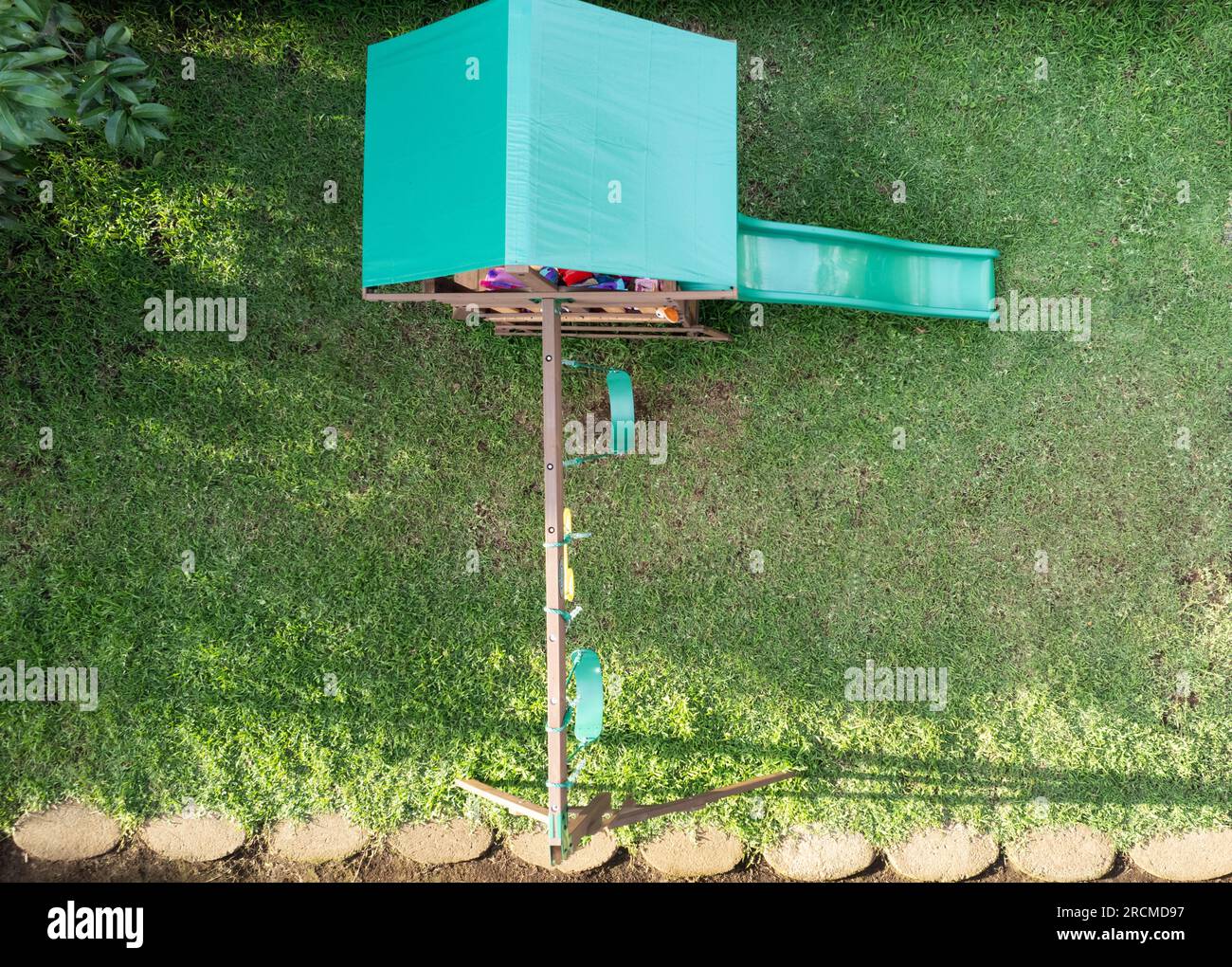 Kid playground with swings and slide on green grass background above ...