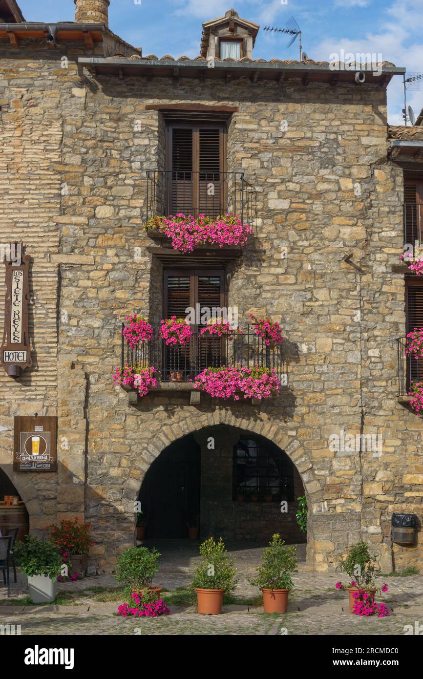 Old stone house with beautiful flowers at the window in the medieval ...