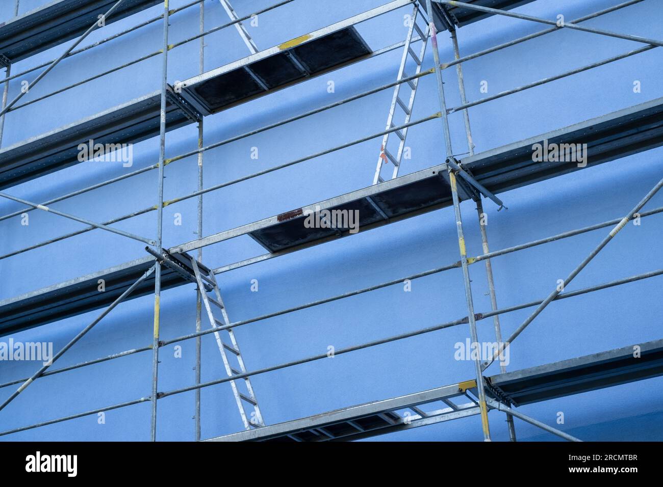 Scaffolding on the construction site in Europe. Insulated blue color ...