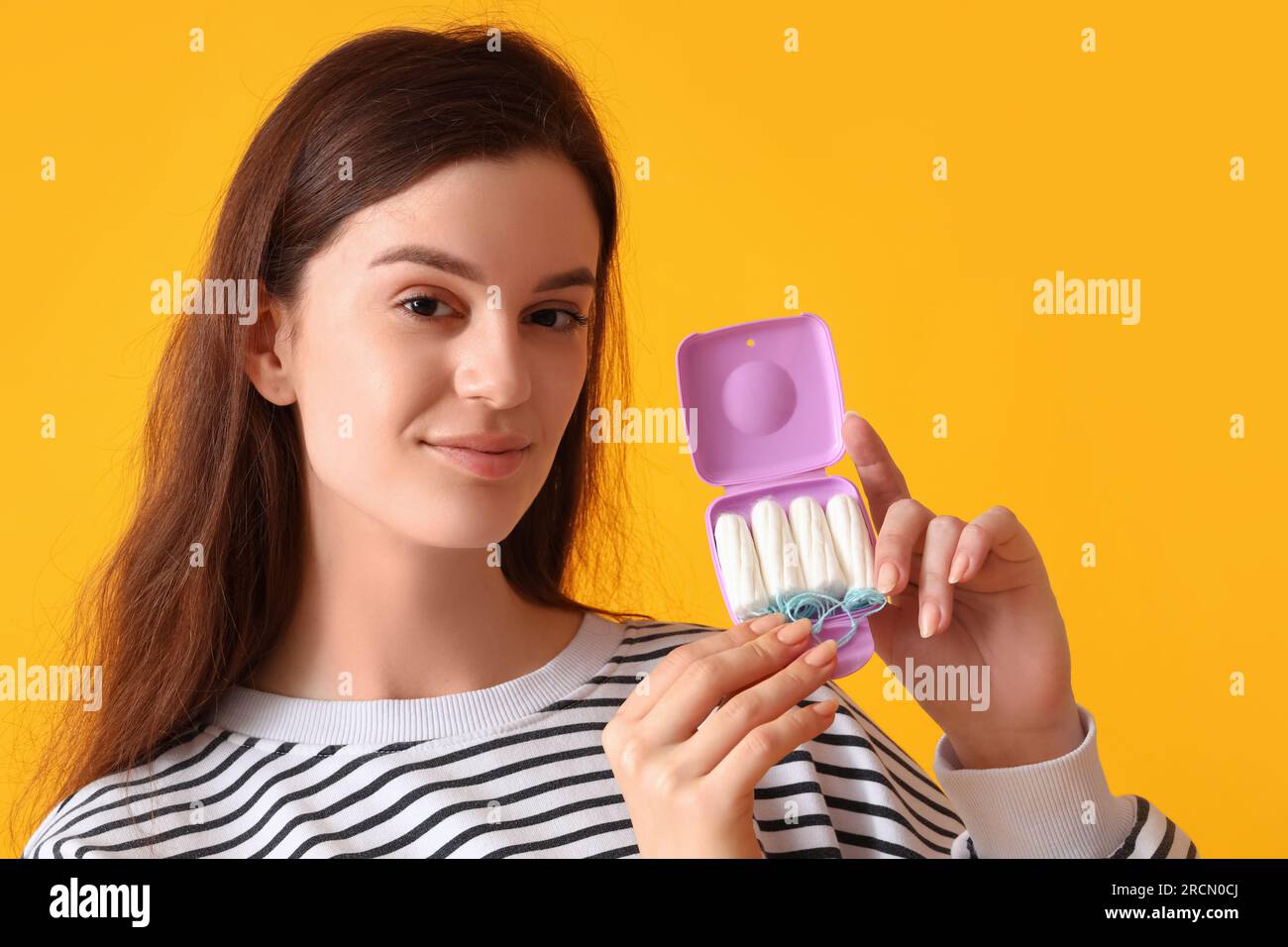 Young woman with box of tampons on orange background, closeup Stock ...