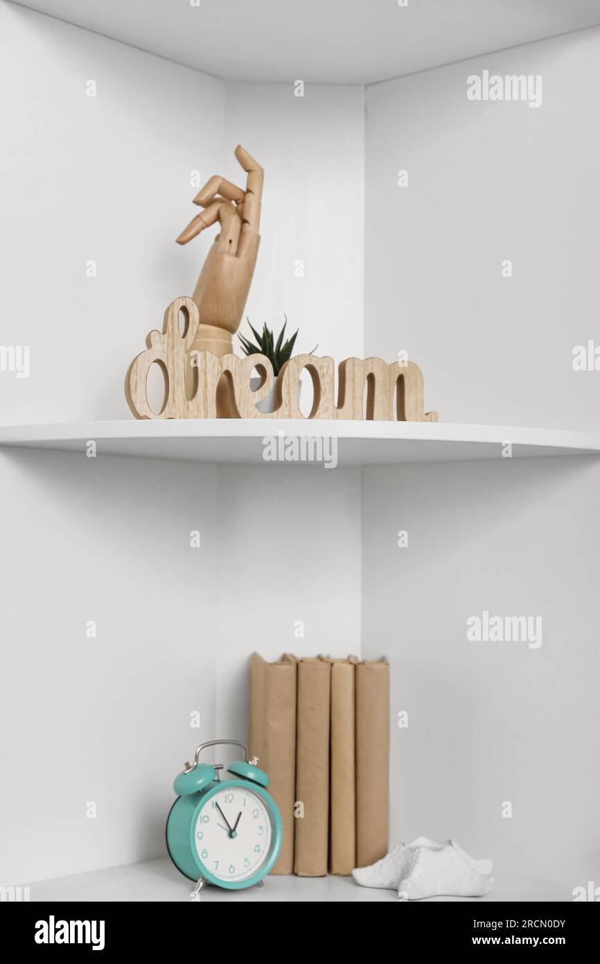 Vintage alarm clock with books and decor on shelves in room Stock Photo ...