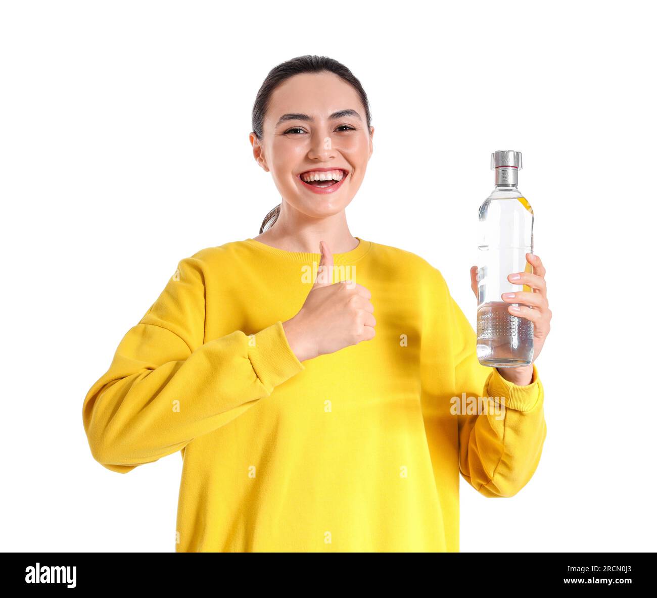 Young woman with bottle of vodka showing thumb-up on white background ...