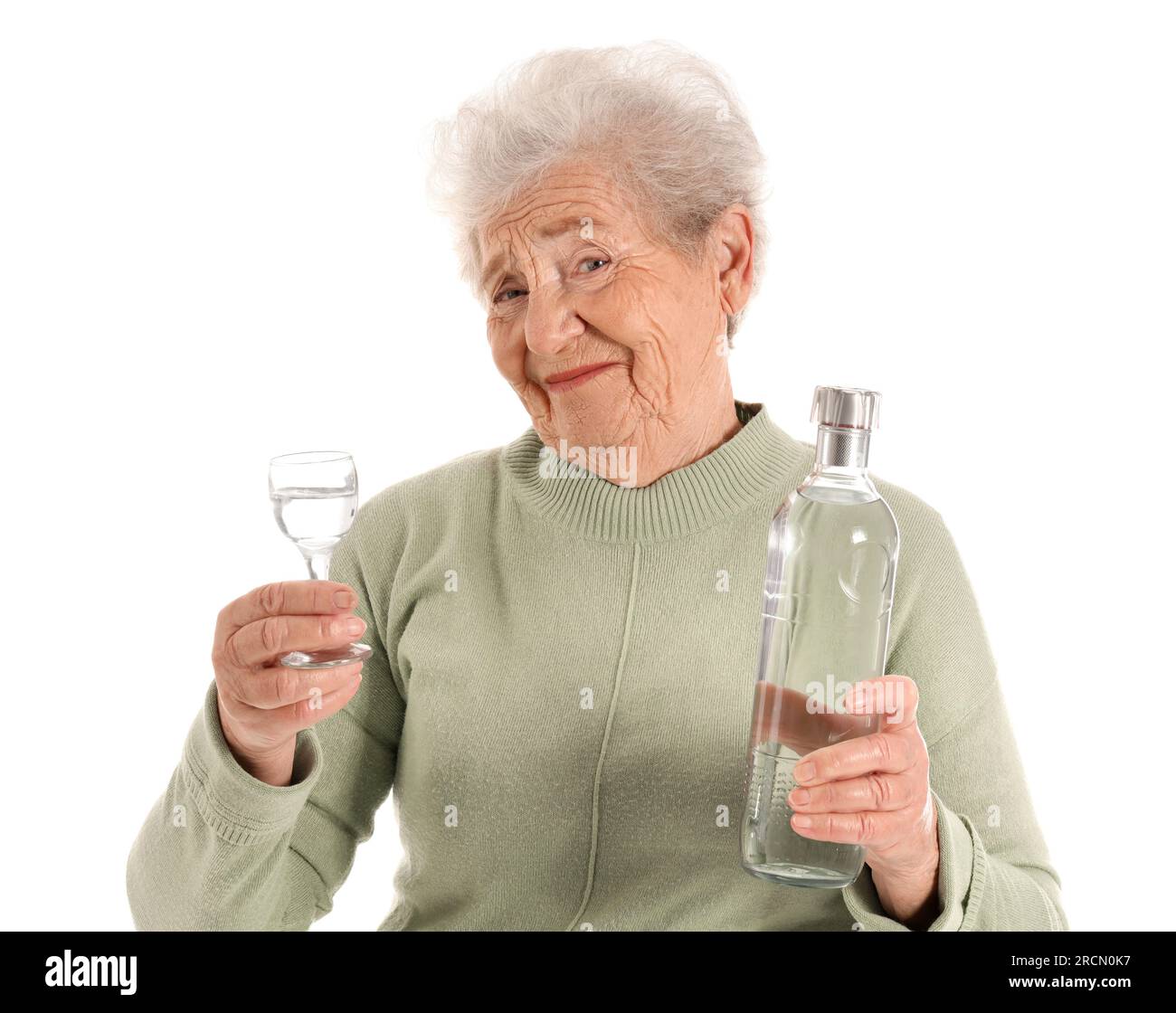 Senior woman with glass and bottle of vodka on white background Stock ...