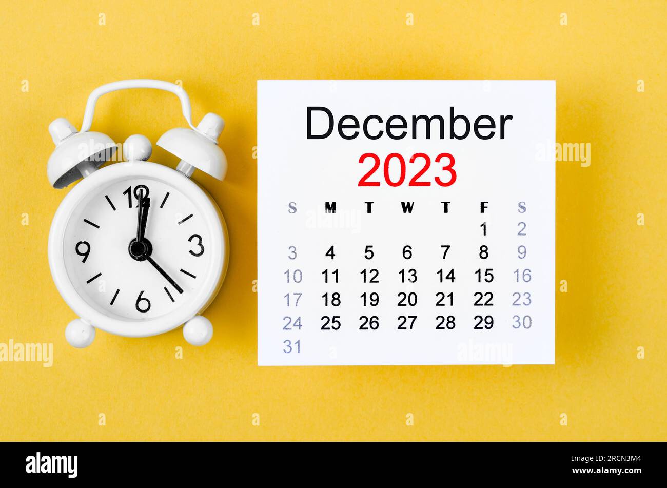 December 2023 Monthly calendar for 2023 year with alarm clock on yellow ...