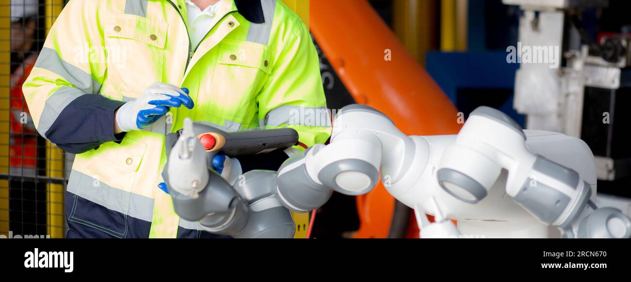 Young engineer man checking and maintenance machine robot arms ...