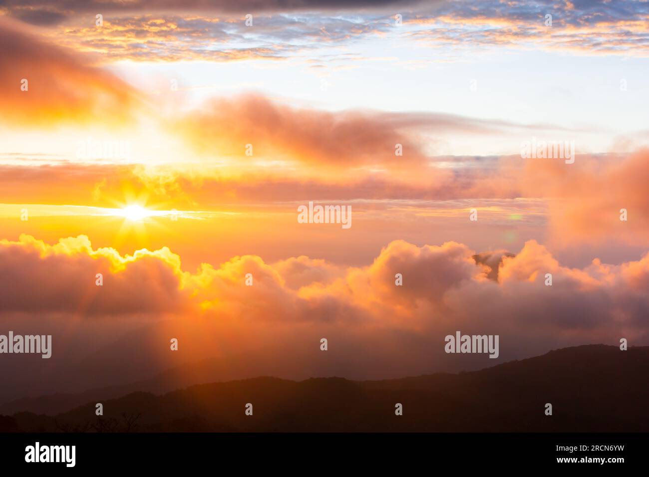 The bright sun rising over the mountain range on a winter day, the ...