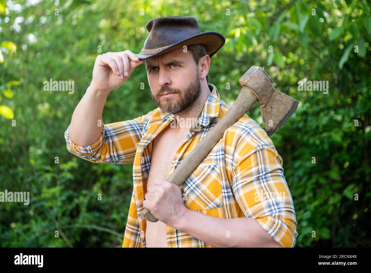 photo of male cowboy with axe. cowboy with axe. cowboy with axe wearing ...