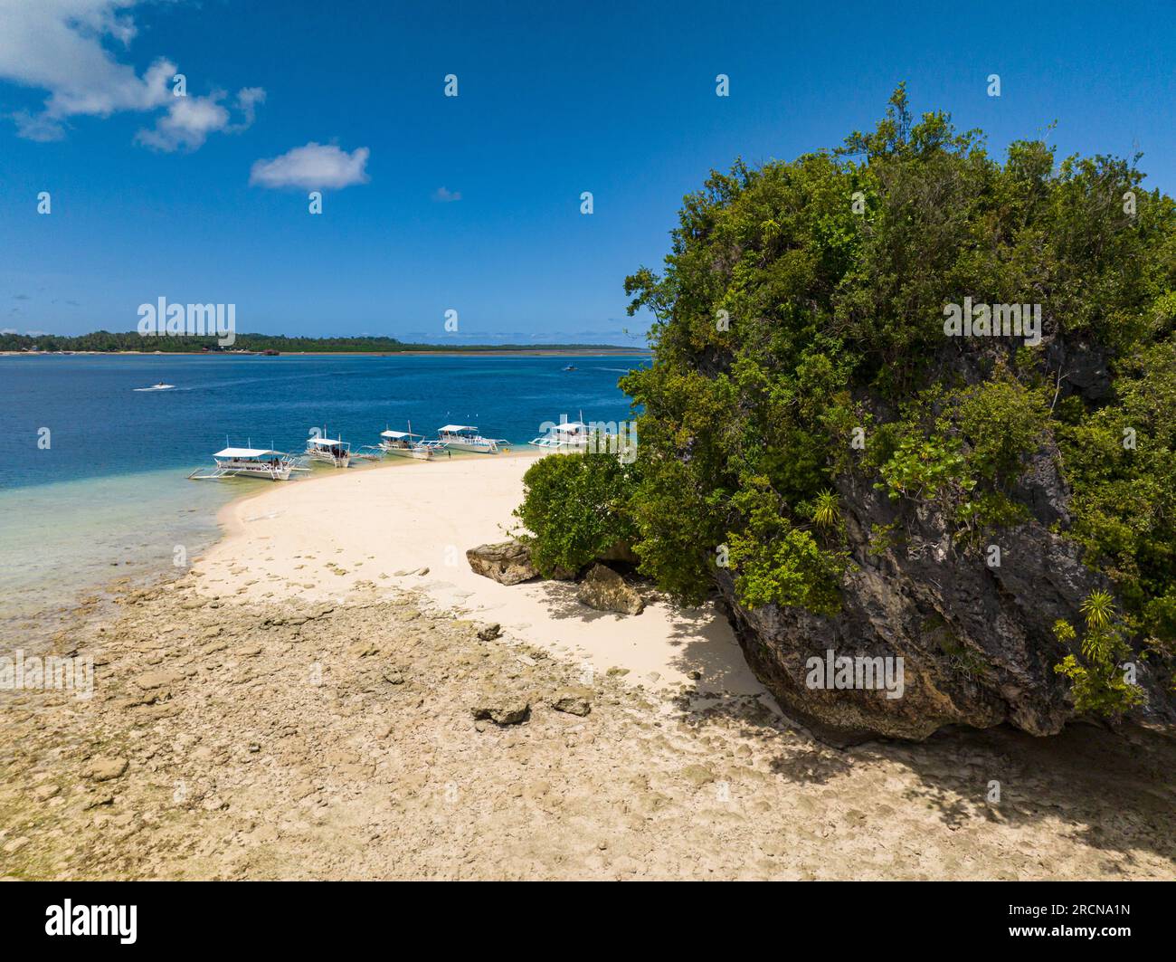 Island with beautiful white sandy beach and group of boats. Turquoise ...