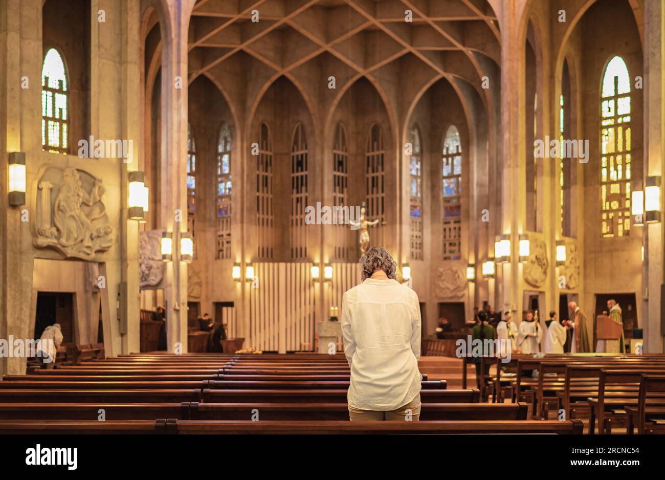 Woman in catholic church. Interior of a Catholic Church with benches ...