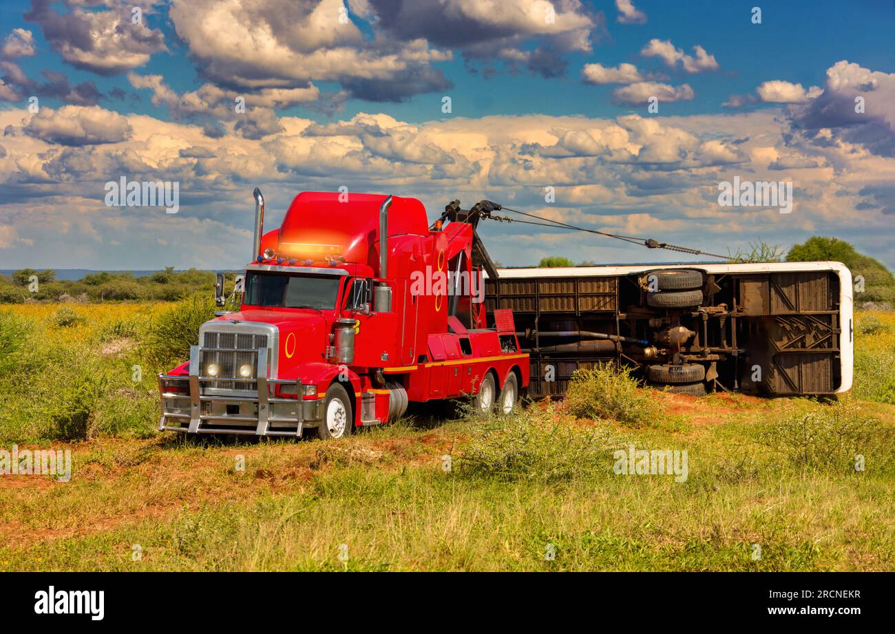 highway accident, red tow truck pulling a bus from the side of the road ...