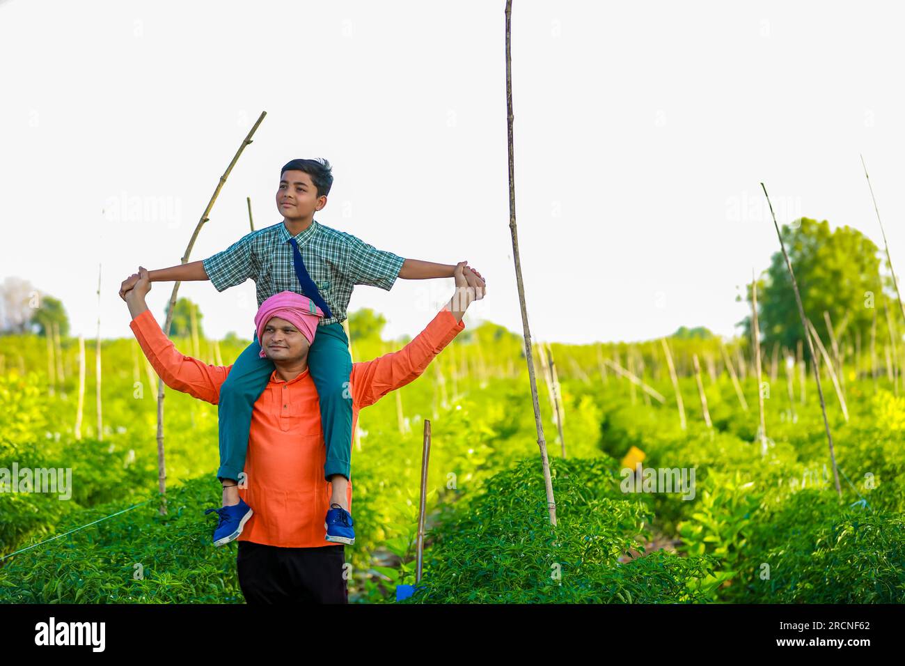 Cute indian farmer child in school uniform with his father at ...