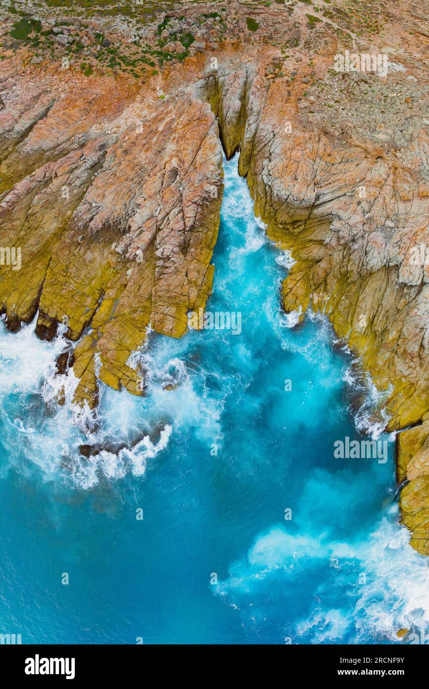 Aerial view of waves crashing onto a rugged eroded coastline at Coles ...