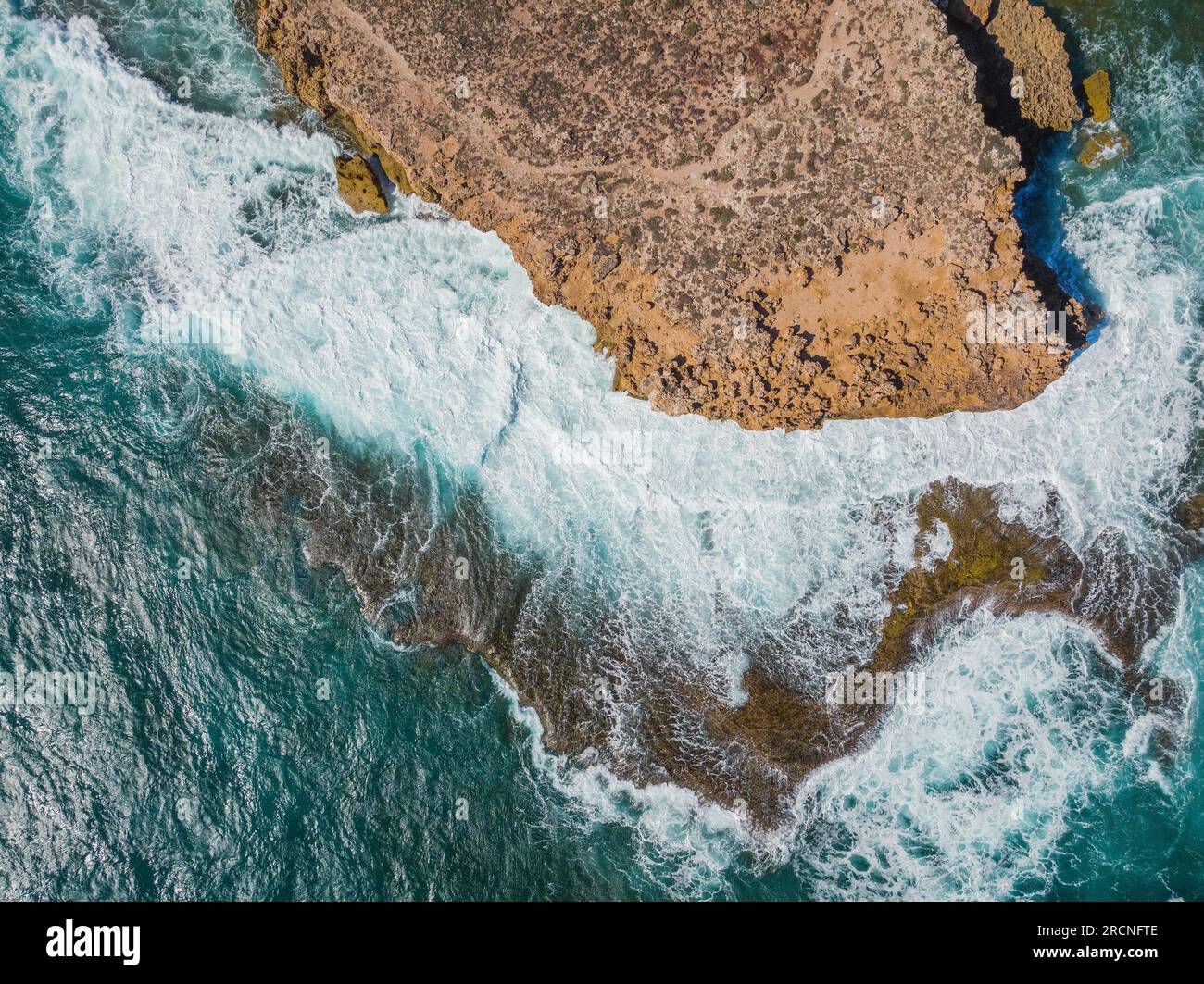 Aerial view of large waves breaking on a rugged eroded coastline at ...