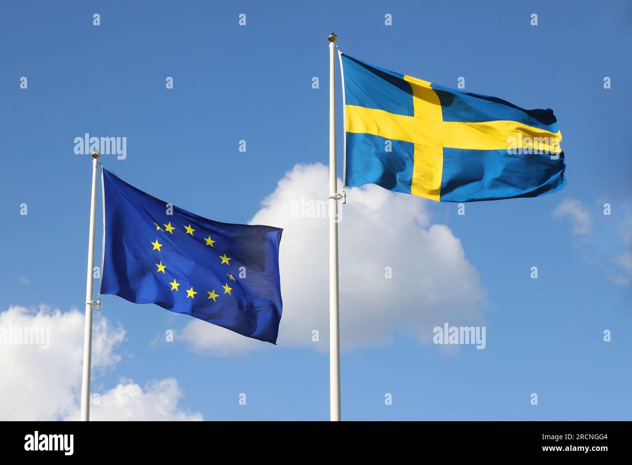 The European Union flag and the national flag of Sweden against the sky ...