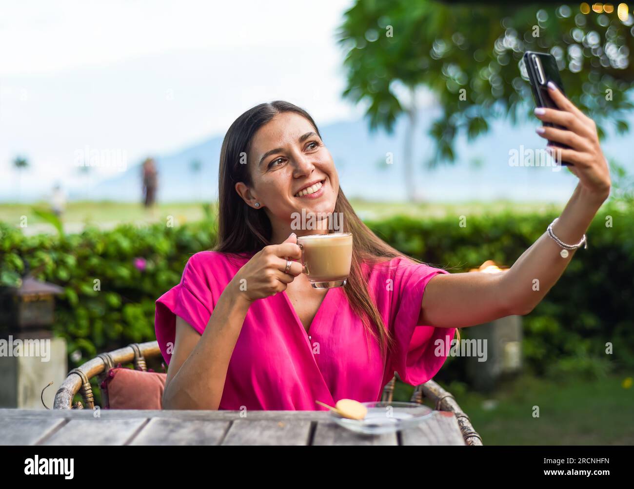 Portrait of smiling russian woman drinking hot capuccino and taking a ...