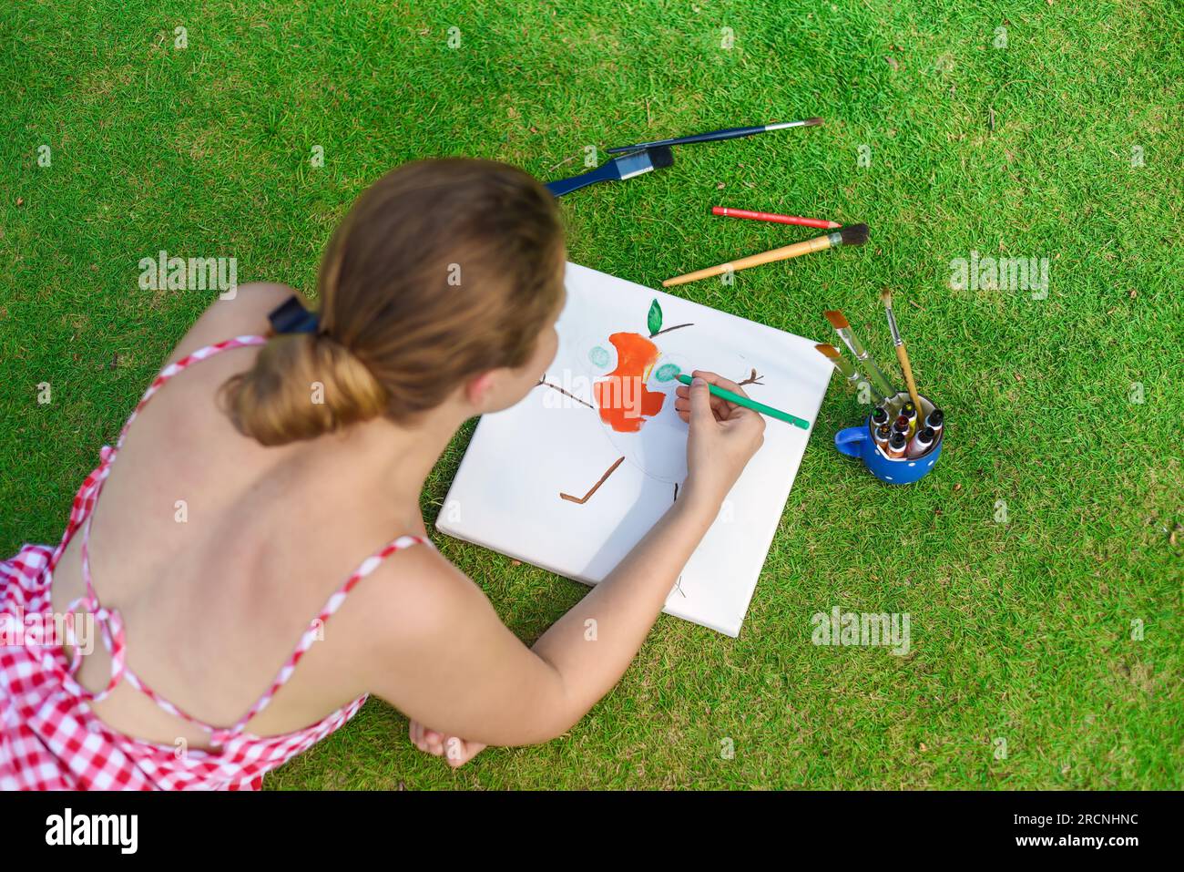 Young woman artist and illustrator drawing witha pencil, laying on a ...