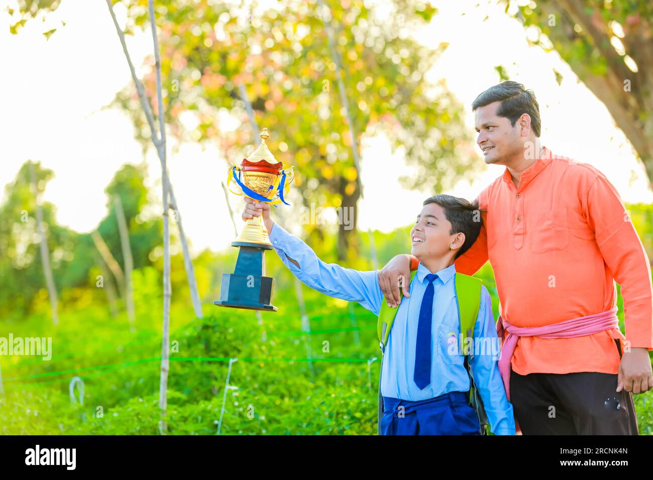Son showing trophy his father , happy farmer and son , indian farming ...