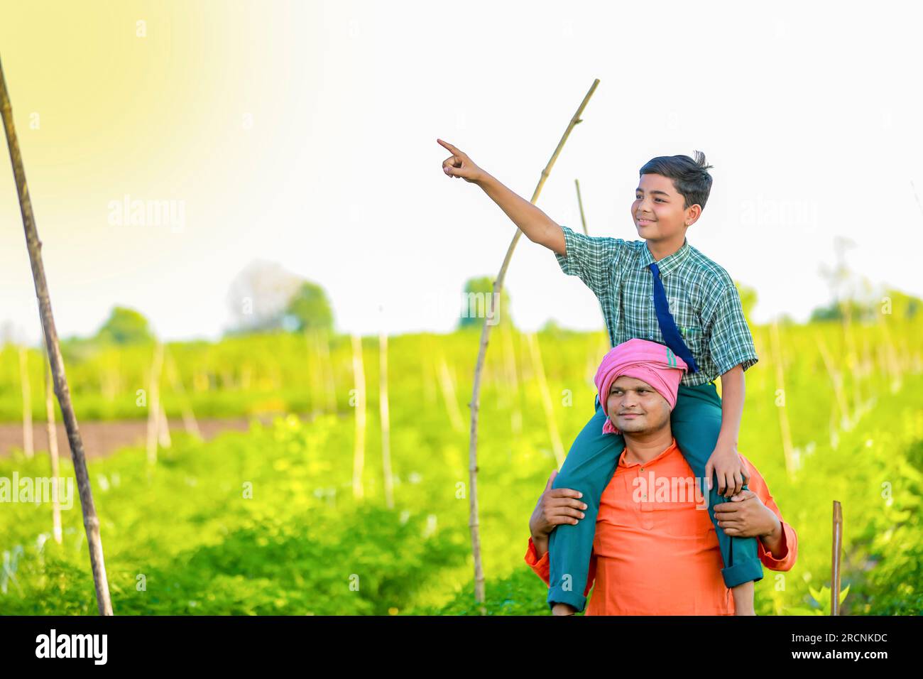 Indian farmer with his son at agriculture field, Father and son are ...