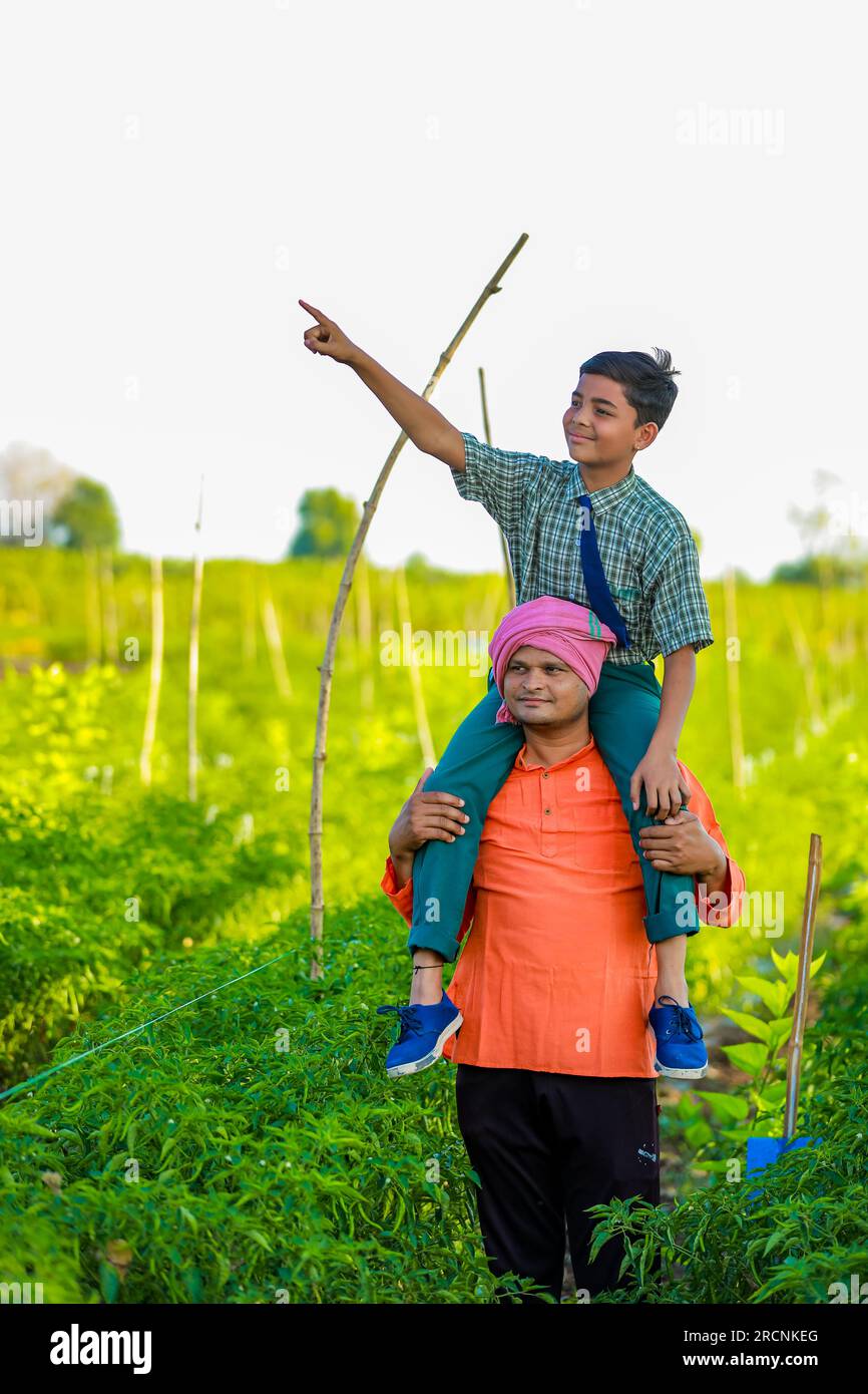 Indian farmer with his son at agriculture field, Father and son are ...