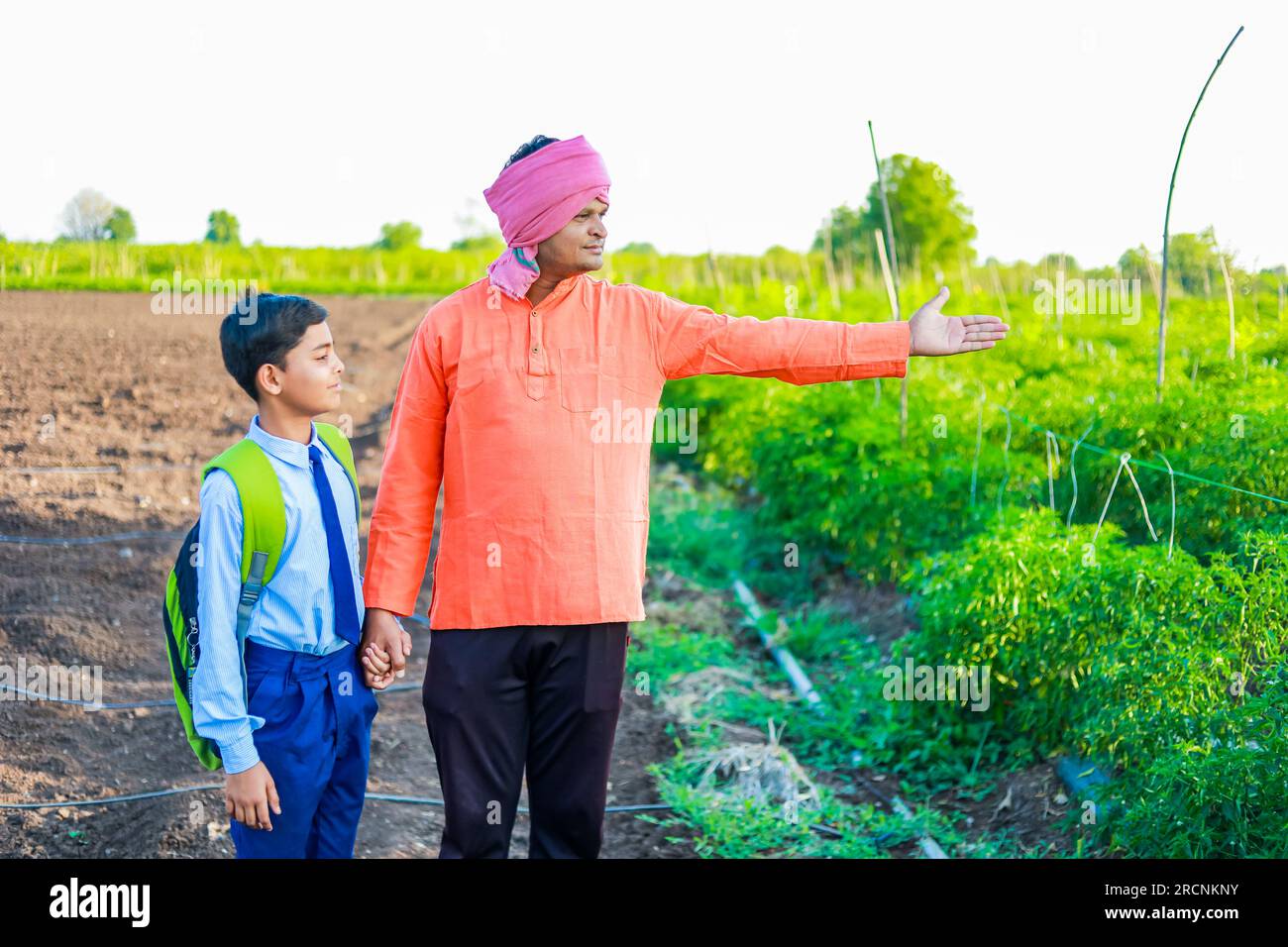 Indian farmer with his son at agriculture field, Father and son are ...