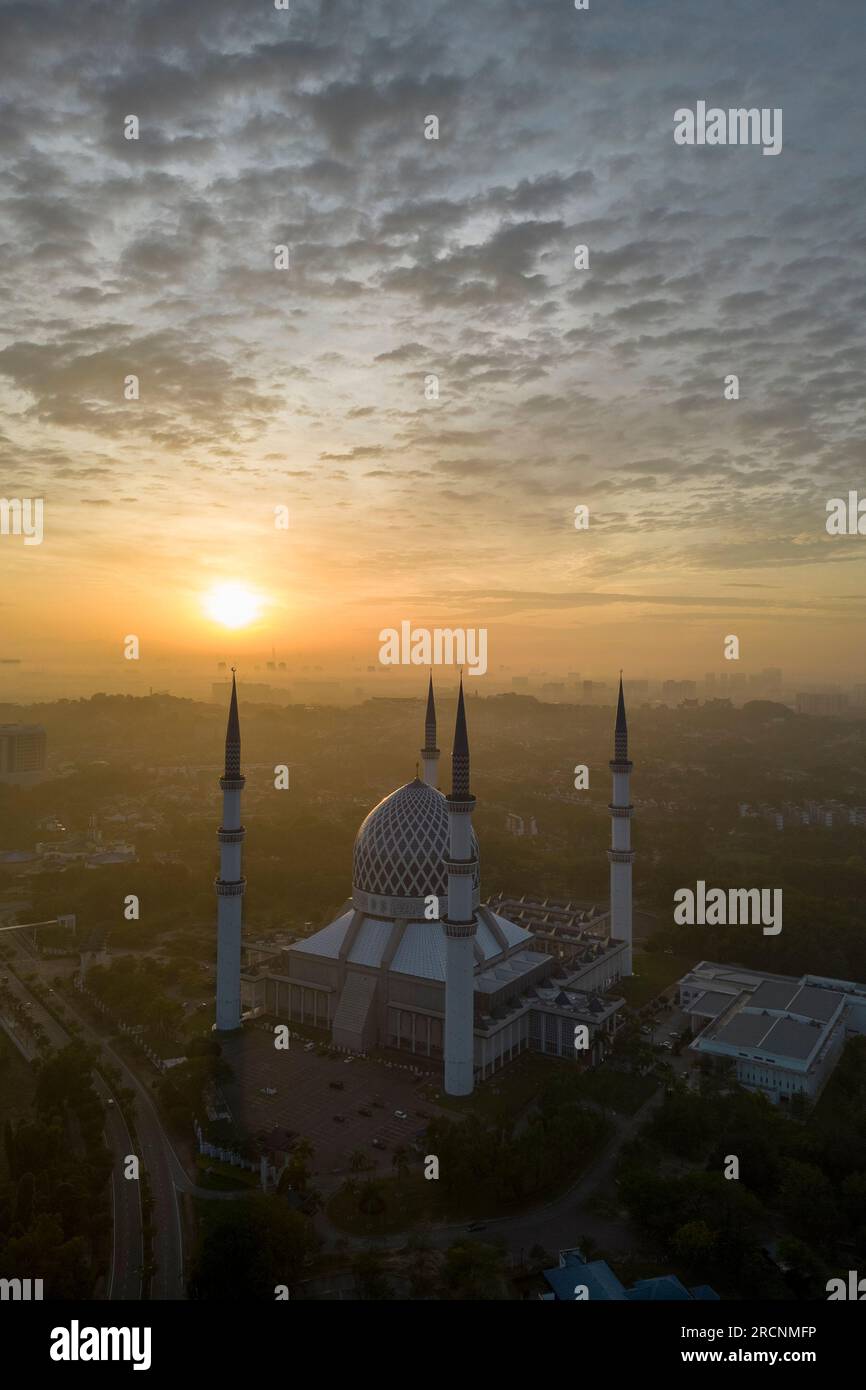 The sun rises behind the Sultan Salahuddin Abdul Aziz Mosque in Shah ...