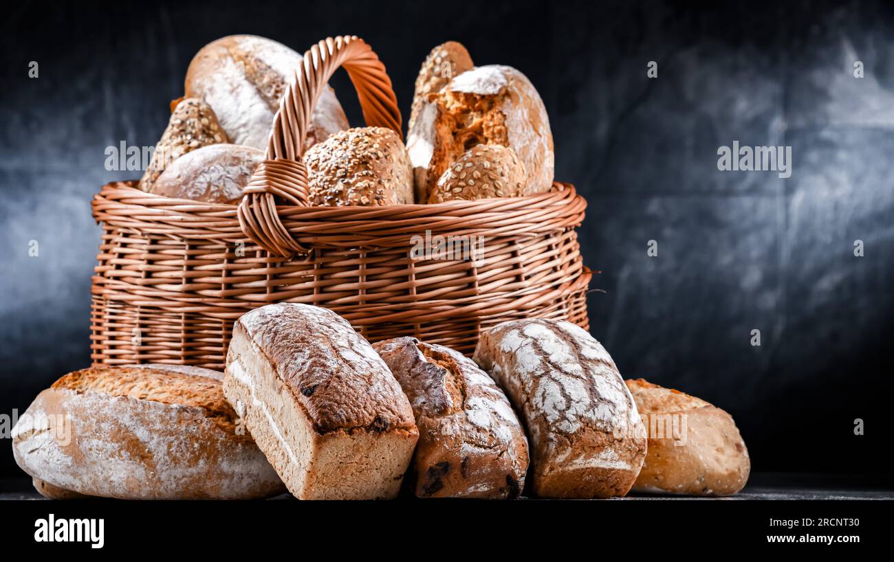 Wicker basket with bakery products including loaves of bread and rolls ...